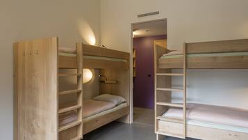 Quarto com beliche de madeira, uma escrivaninha e uma cadeira.