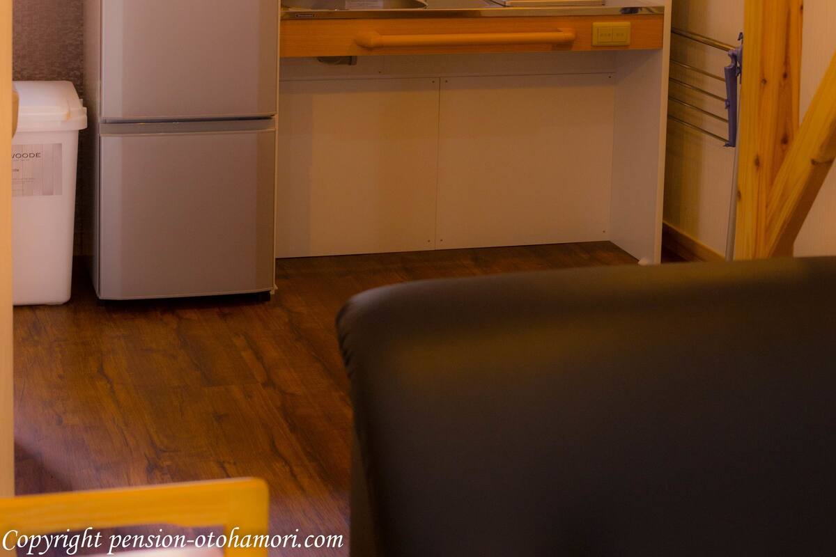 Uma cozinha compacta com geladeira, pia e bancada.