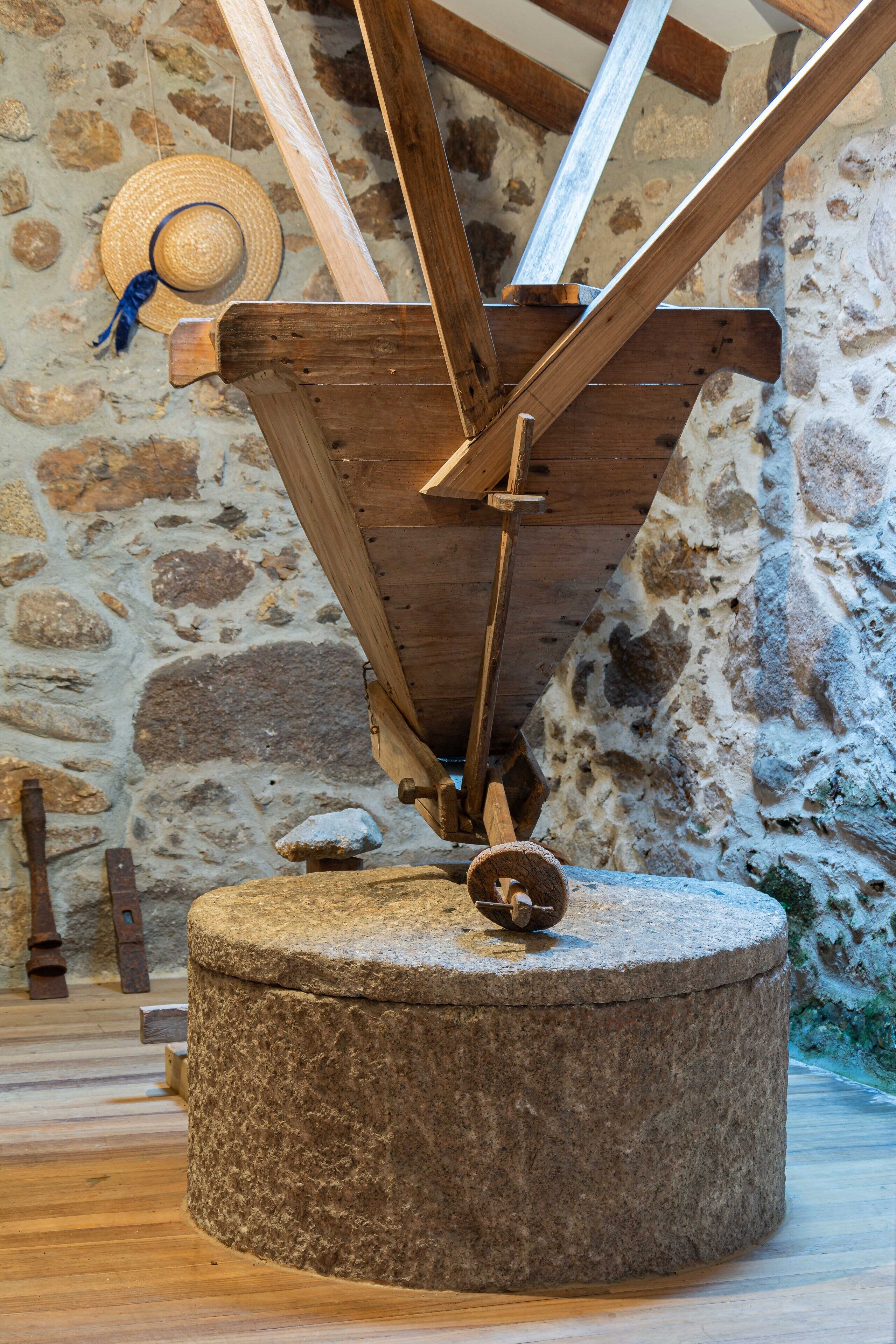 Estrutura de madeira rústica com base de pedra, possivelmente um artefato histórico ou parte da arquitetura de um edifício.