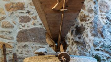 Estrutura de madeira rústica com base de pedra, possivelmente um artefato histórico ou parte da arquitetura de um edifício.