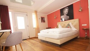 Um quarto com cama, escrivaninha e cadeira.