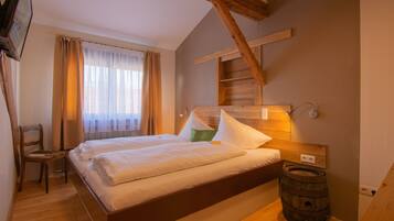 Quarto com cama de madeira, uma cadeira, um barril de madeira e uma janela com cortinas.