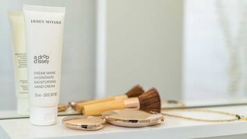 Exposição de produtos para a pele com um tubo, uma compactação e pincéis sobre uma superfície branca.