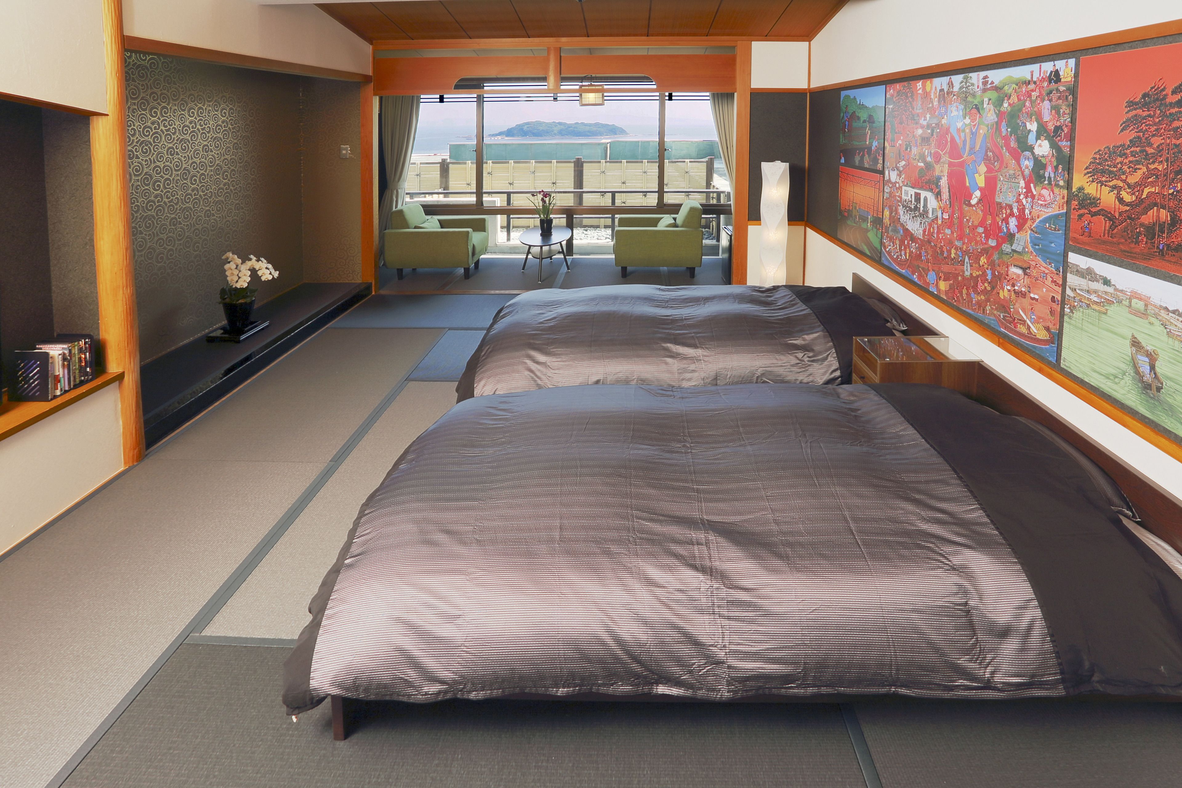 Quarto de hotel com duas camas, vista para o mar e um quadro grande na parede.