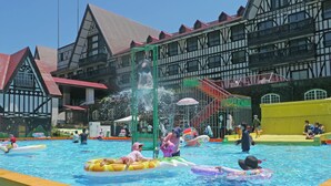 Uma área de piscina com um edifício tradicional europeu ao fundo.