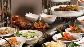 Buffet com diversos pratos, incluindo frutos do mar, saladas e um centro de carne assada.