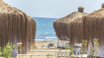 Uma praia privada, espreguiçadeiras, guarda-sóis de praia