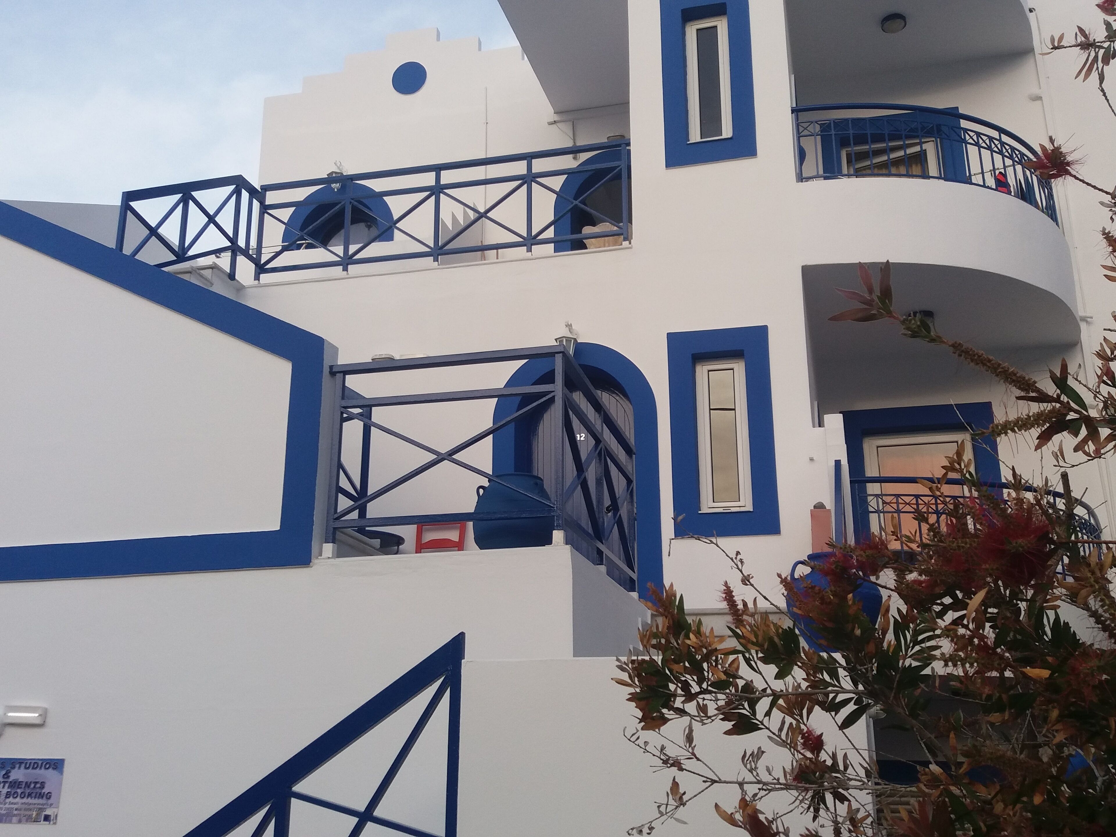 Um edifício com esquema de cores azul e branco, com varandas e uma escadaria.