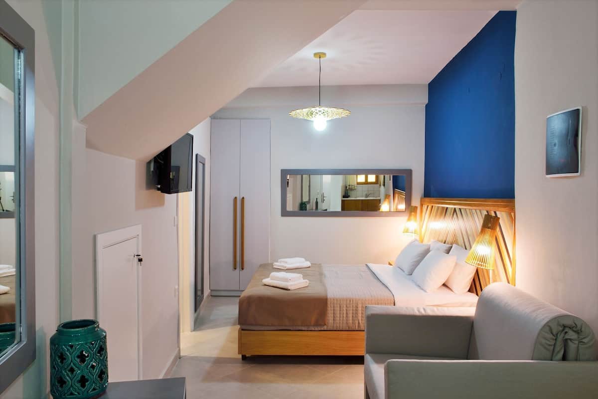 Quarto com cama, mesa de cabeceira, abajur e espelho.