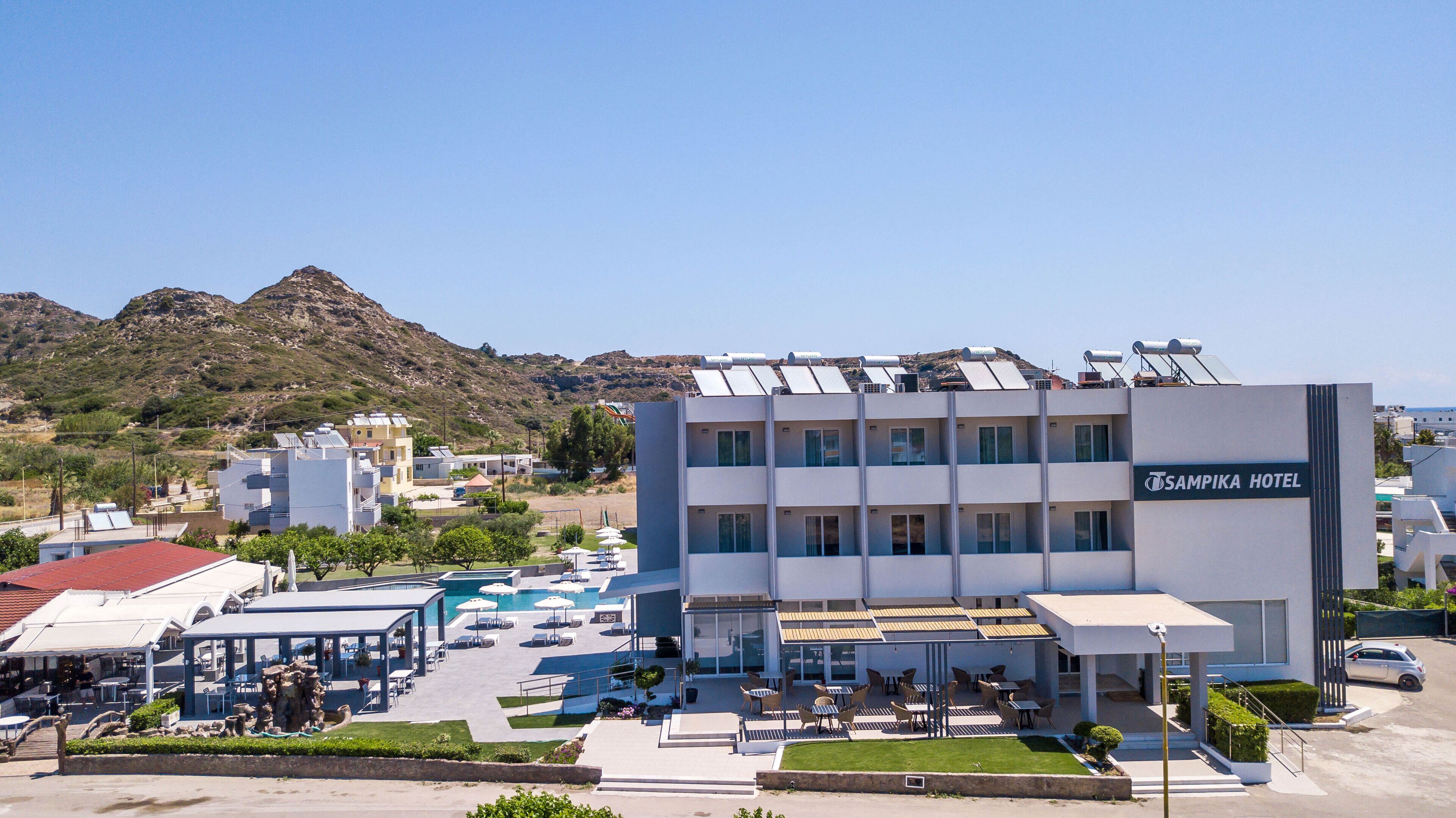 Um hotel moderno com piscina no terraço, área de estar ao ar livre e vista para a paisagem circundante.