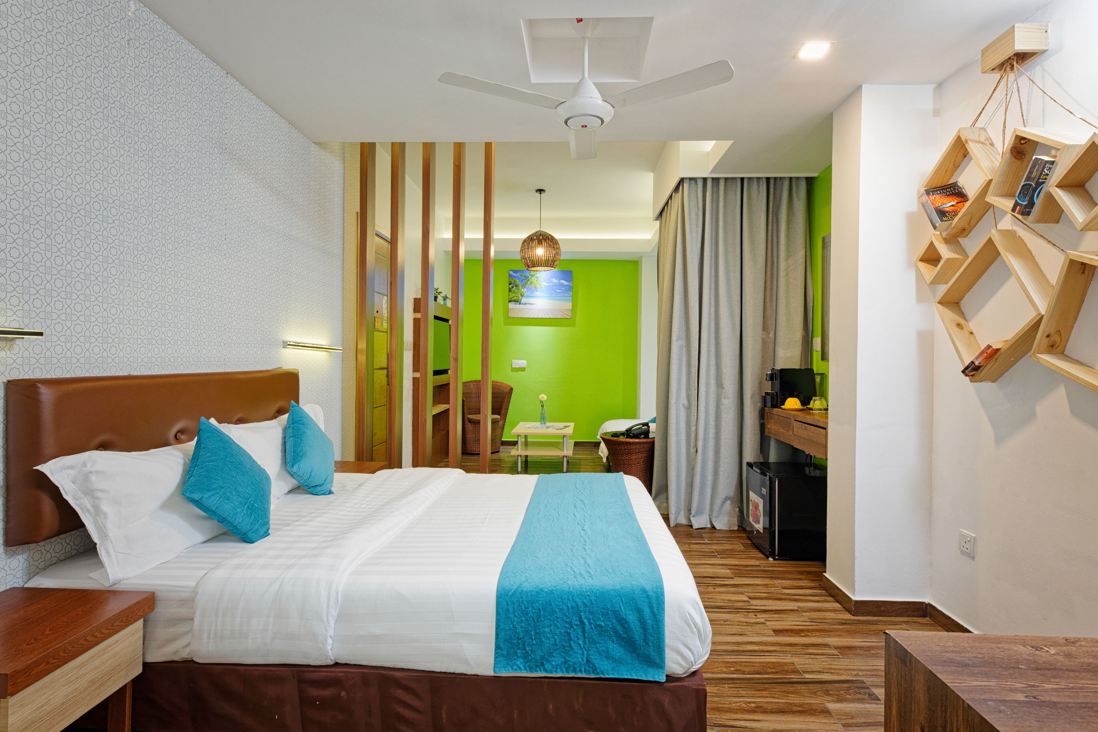 Quarto de hotel com cama, mesa de cabeceira e escrivaninha com cadeira.