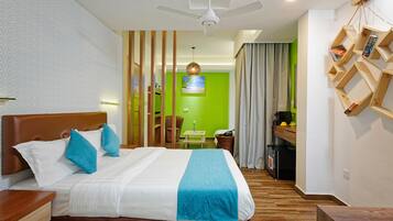 Quarto de hotel com cama, mesa de cabeceira e escrivaninha com cadeira.