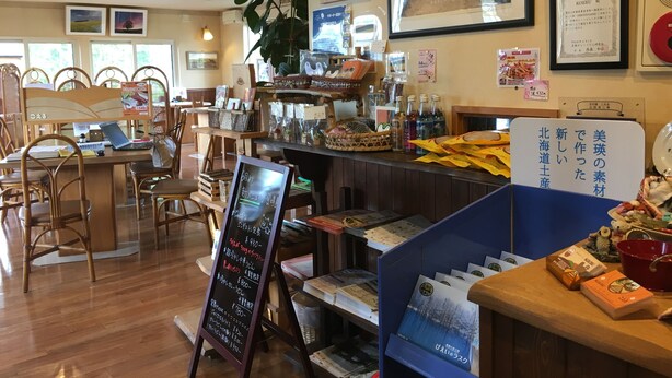 Uma livraria com móveis de madeira, uma variedade de livros e um menu em lousa.