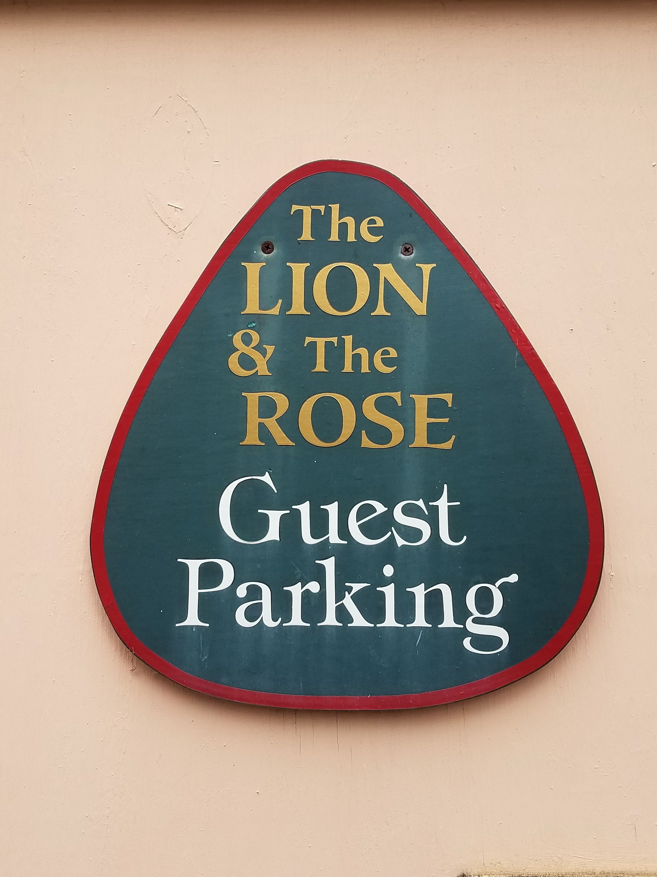 Placa indicando 'Estacionamento The Lion & The Rose'.