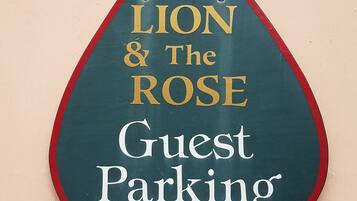 Placa indicando 'Estacionamento The Lion & The Rose'.