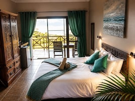 Quarto com cama grande, vista para o exterior, guarda-roupa de madeira e um quadro na parede.