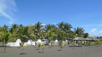 Praia particular, areia preta, barracas de praia de cortesia