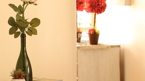 Uma mesa com um vaso de flores, um livro e uma pequena planta em vaso.