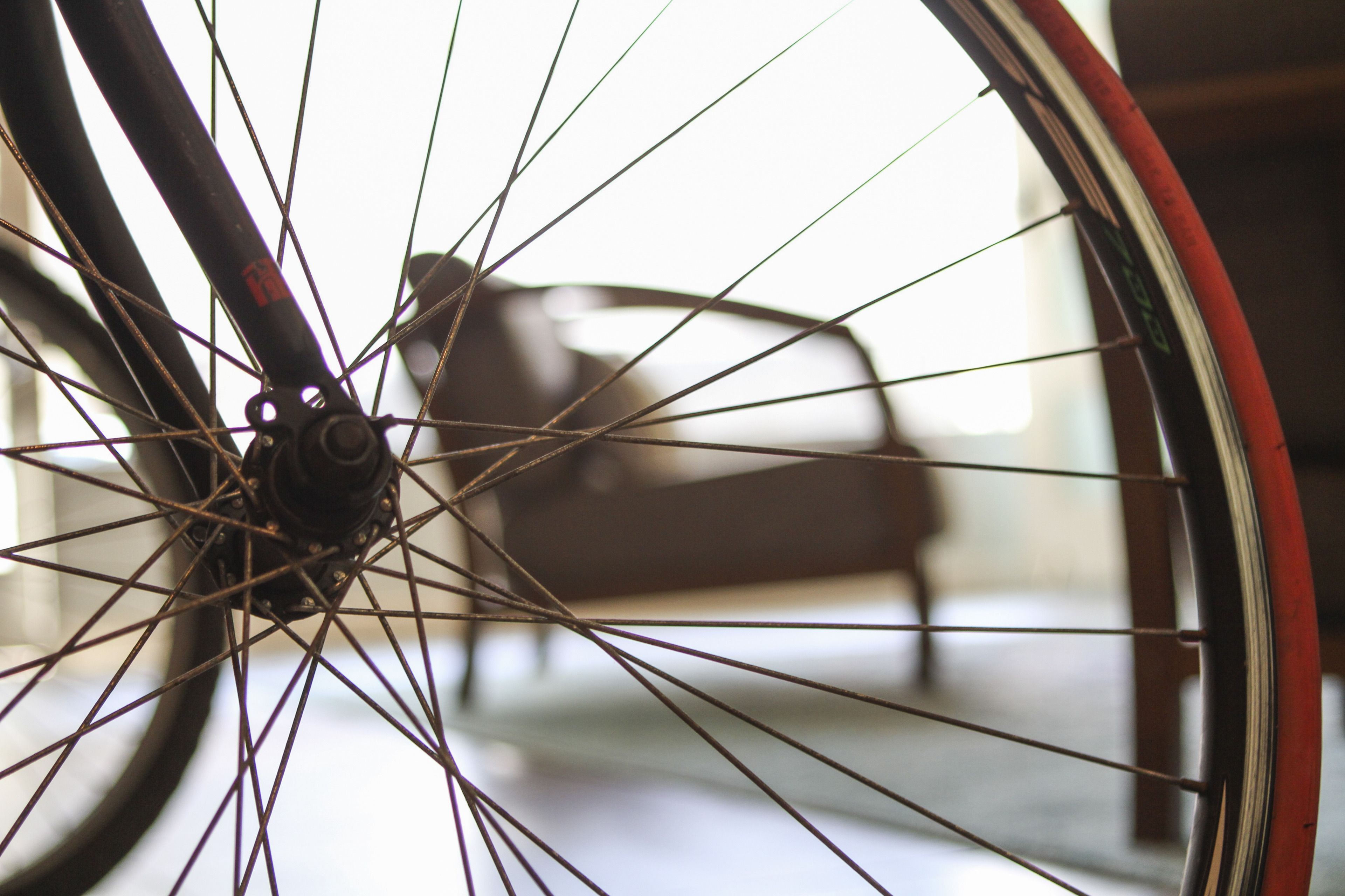 Um close-up de uma roda de bicicleta com raios e cubo, com fundo desfocado.