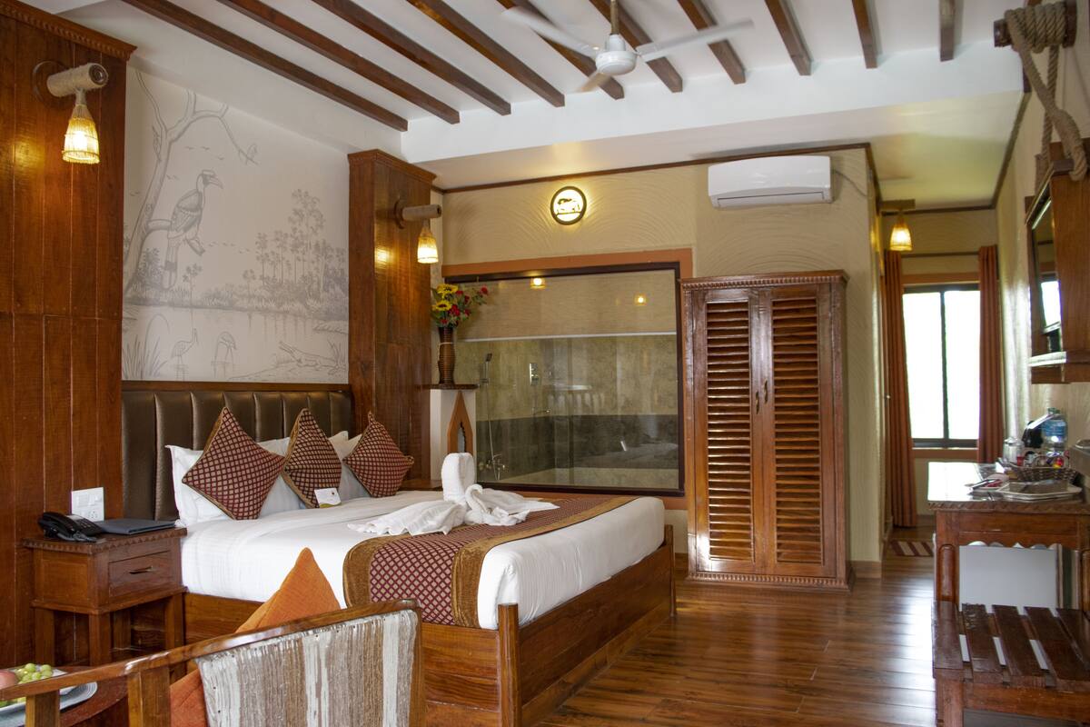 Um quarto espaçoso com uma cama grande, cabeceira de madeira e uma mesa de cabeceira.