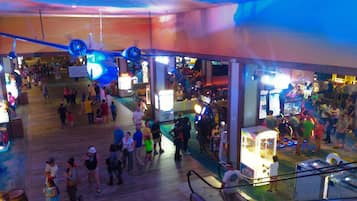 Um espaço interno movimentado, com diversas atrações e pessoas.