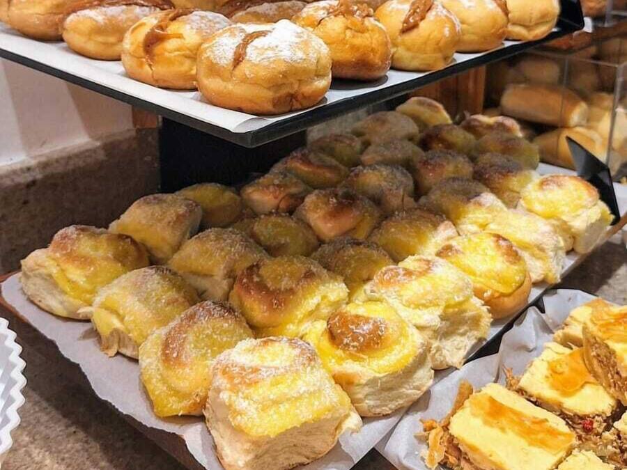 Uma variedade de doces e produtos de panificação em bandejas.