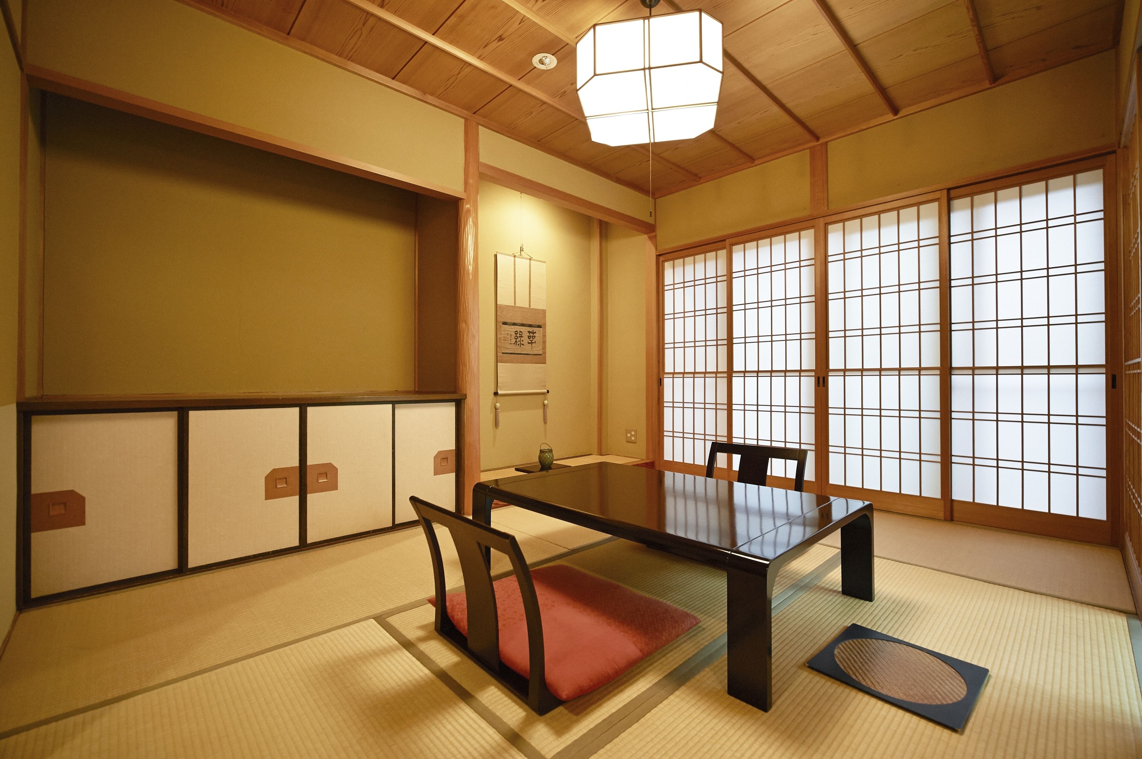 Um quarto japonês tradicional com tatames, uma mesa baixa e portas deslizantes.