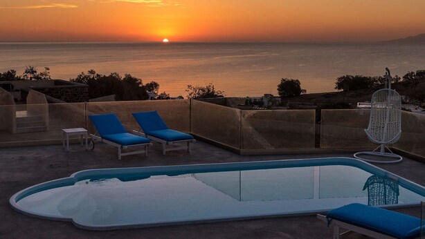 Piscina no terraço com espreguiçadeiras e poltronas, com vista para o pôr do sol sobre o mar.