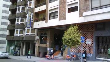 Um hotel com entrada no andar térreo, área de estar ao ar livre e escadaria visível que leva à entrada.