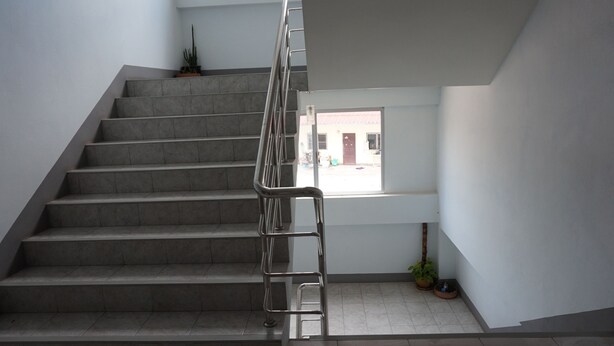 Escada com guarda-corpos de metal, descendo para um nível inferior.