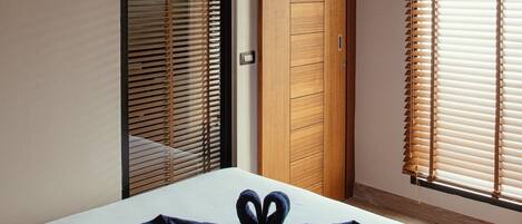Quarto com cama, guarda-roupa de madeira e janela com persianas.