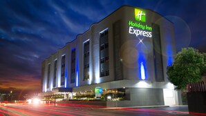 Edifício Holiday Inn Express com design moderno, grandes janelas e uma placa bem visível.