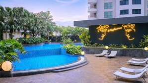 Piscina com espreguiçadeiras e um letreiro neon.