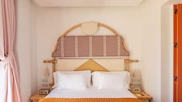 Quarto de hotel bem arrumado, com uma cama, duas mesas de cabeceira, um abajur e um telefone.
