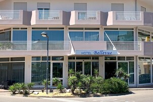 Um hotel chamado 'Hotel Bellevue' com design moderno, apresentando várias varandas e grandes janelas.