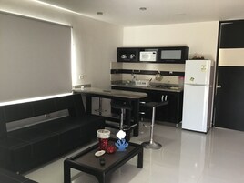 Uma cozinha moderna com esquema de cores preto e branco, micro-ondas embutido e geladeira.
