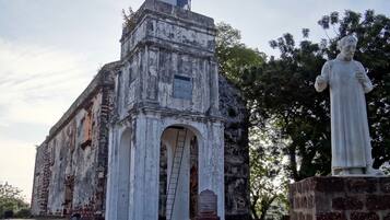 Um edifício histórico com uma estátua em frente.