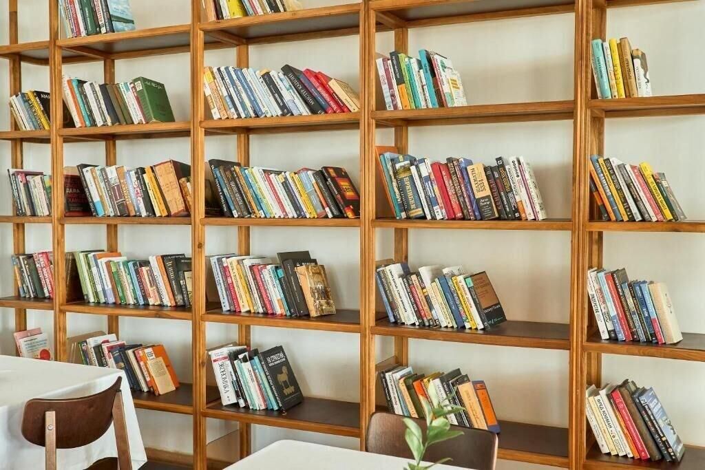 Uma biblioteca com várias estantes de madeira repletas de livros.