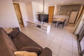 Apartamento de Luxo, 2 quartos, vista para o mar, em frente à praia | Sala de estar | Televisor de ecrã plano de 40 polegadas com canais por cabo 