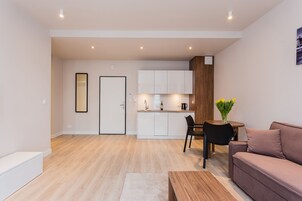 Um apartamento moderno com sala de estar, cozinha compacta e área de refeições.