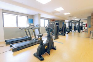 Uma academia com esteiras, elípticos e equipamentos de musculação.