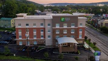 Edifício da Holiday Inn Express & Suites, com um estacionamento e uma rua em primeiro plano.