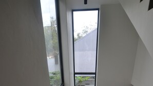 Um interior moderno com uma escada de madeira que leva a uma varanda.