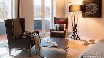 Uma sala de estar moderna com sofá, poltrona, mesa de centro e abajur.