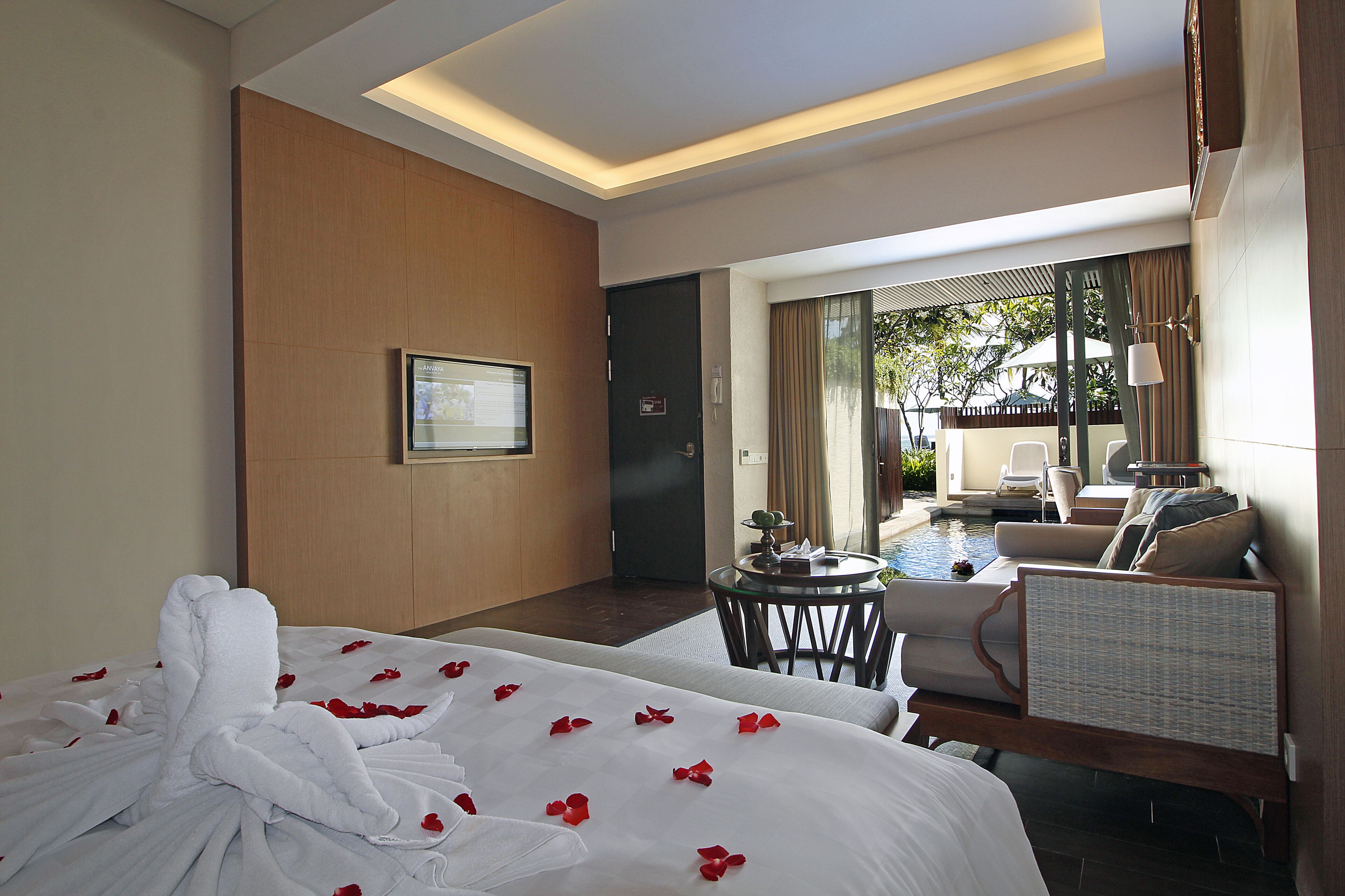 Quarto de hotel com cama, mesa pequena, cadeira e sofá.