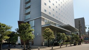 Um hotel moderno e alto, com entrada imponente e passarela coberta.