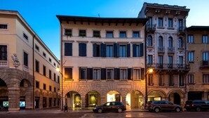 Um edifício histórico com várias arcos e varandas, apresentando um estilo arquitetônico europeu clássico.