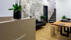 Um interior moderno com um balcão de recepção, uma escadaria e uma área de refeições.