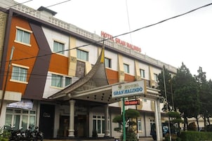 Um hotel com fachada moderna, entrada imponente e placa indicando o nome 'Hotel Gran Malindo'.