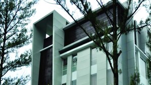 Um edifício moderno com uma placa que diz "OASIS SILIWANGI".